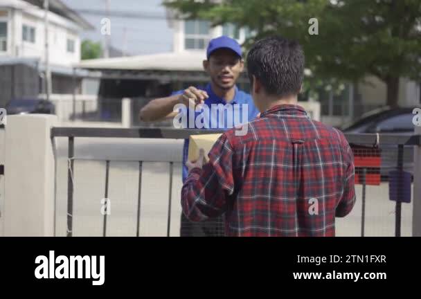 Postman delivering parcel home with smile and happy face, Asian man ...