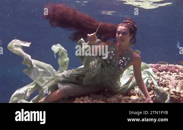 Underwater model free diver poses for camera on background of corals in ...