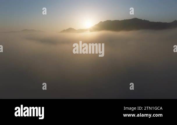 Flying through cinematic golden glowing cloudscape towards golden ...