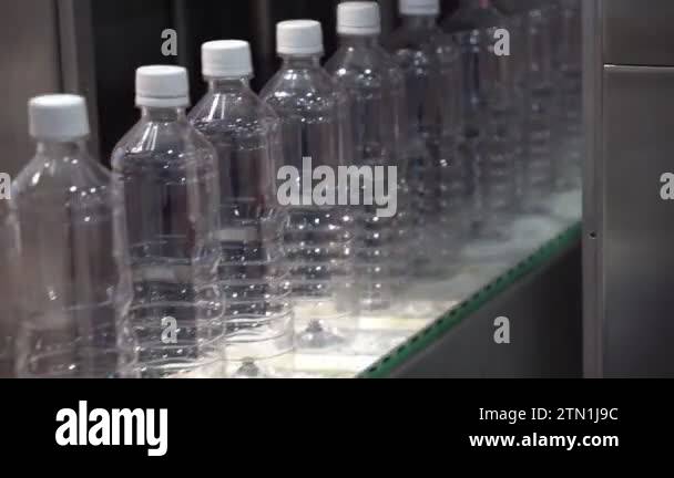 The plastic bottle filling process in the conveyor belt. The drinking ...
