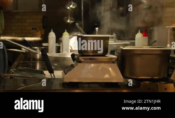 Professional restaurant kitchen in stainless steel. Male cooks preparing in restaurant kitchen ...