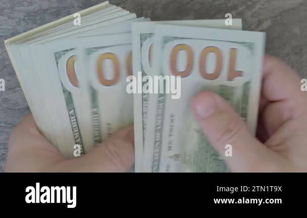 Counting in the hands of 100 US dollar banknotes of the new type ...