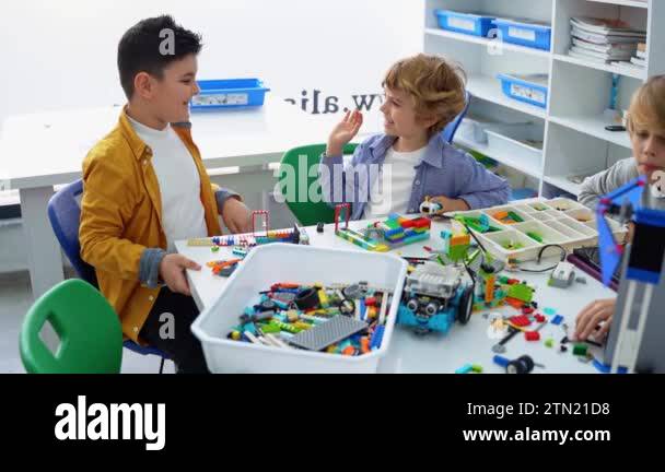 Robotics programming class. Children construct and code Robot. STEM education using constructor ...