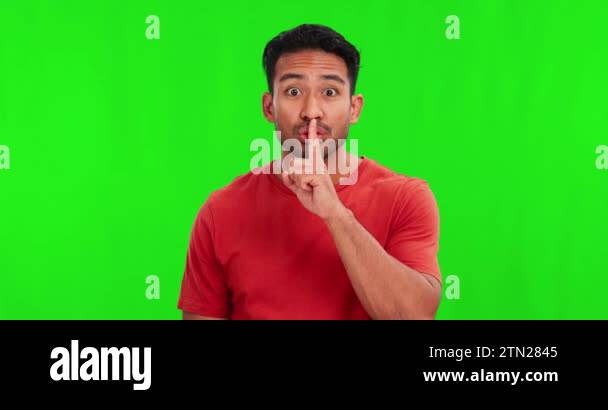 Face, green screen and man with finger, lips and silent with secret ...