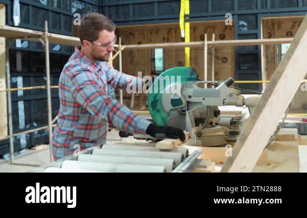 Building contractor worker using hand held worm drive circular saw to ...