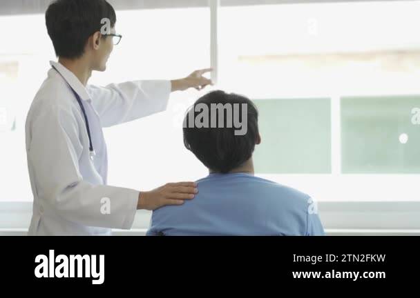 Happy doctor visiting young male patient to bring good news and ...