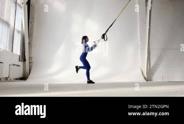 Fit woman in a special workout outfit performing a single-leg squat ...