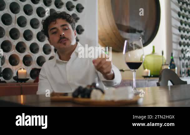 Relaxed italian guy enjoying red wine with appetizers sitting cozy ...