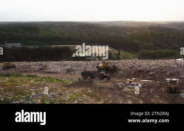 Tractor and bulldozers on the landfill site garbage dump. Polluted ...