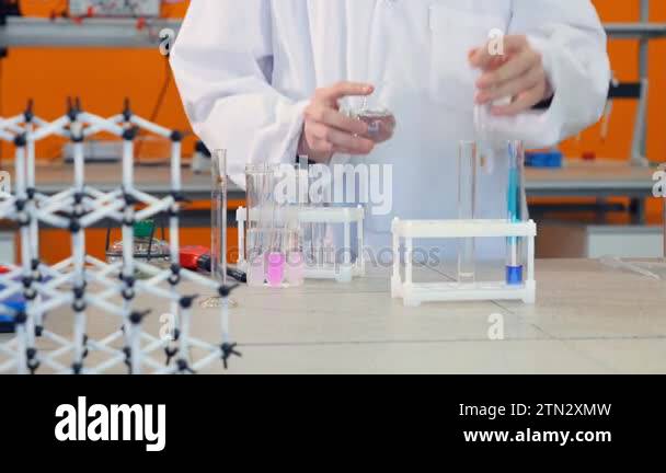 Secondary school student doing chemistry test in the lab. Hands add ...