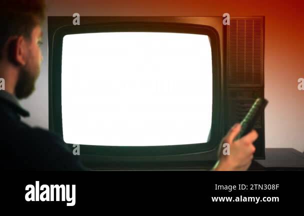 Concentrated man holding remote control and changing TV channels of ...