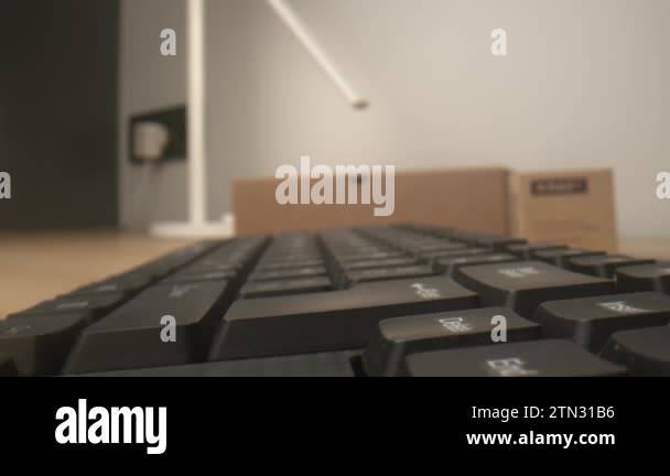Person types on computer keyboard against cardboard boxes in empty room ...