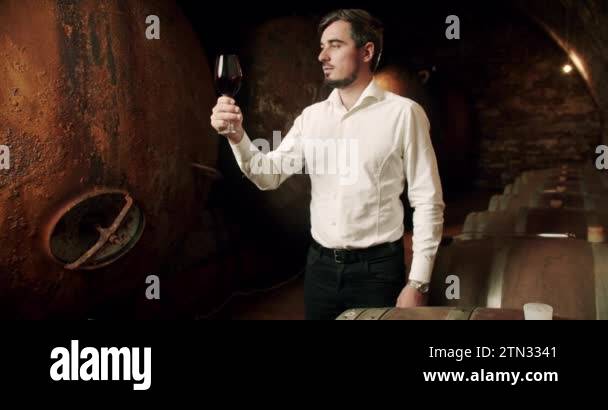 Happy successful male winemaker is tasting a flavor and checking fresh ...