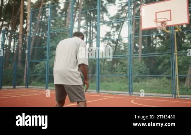 Portrait of African American basketball player from back bouncing and ...