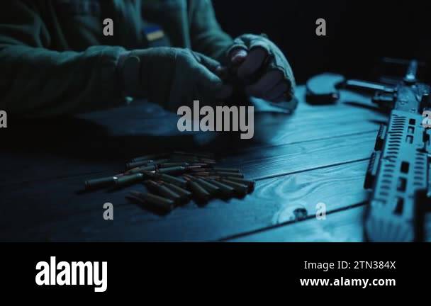 Male hands insert cartridges into the magazine of a assault rifle ...