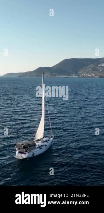 Immerse yourself in the splendor of the coast as a sailboat embarks on ...