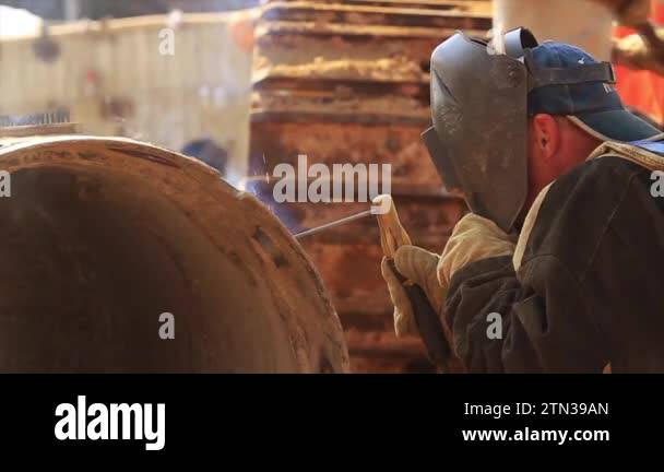 Welder working on a pipeline. Close up shot welder until welding ...