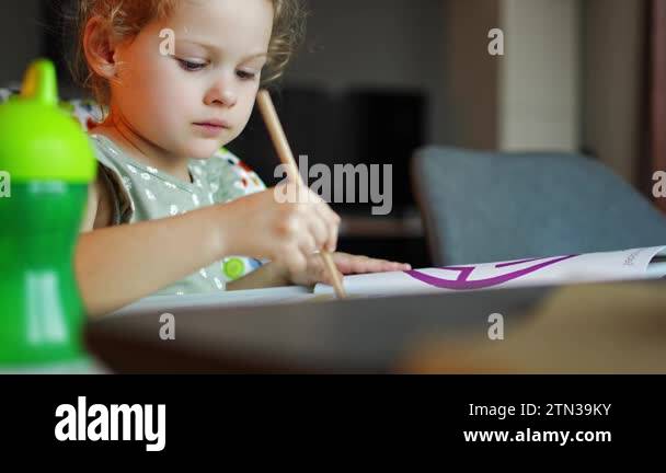 Little girl enjoys painting process, using paintbrush into watercolor ...