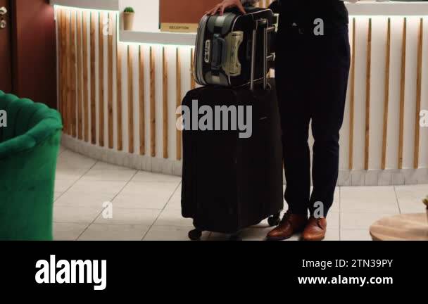 Cheerful smiling professional bellboy in formal attire with baggage ...