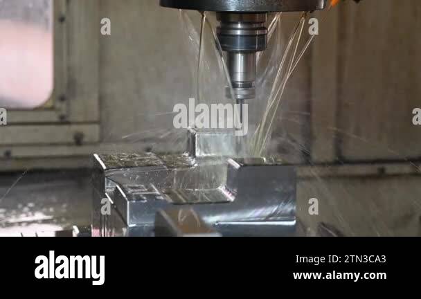 The CNC milling machine cutting the tire mold parts with oil coolant ...