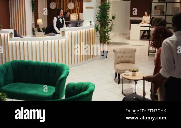 Friendly smiling concierge personnel welcoming guests in hotel lobby ...