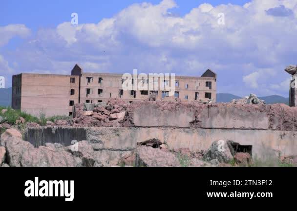 Large ruined building with pile of construction debris and concrete ...
