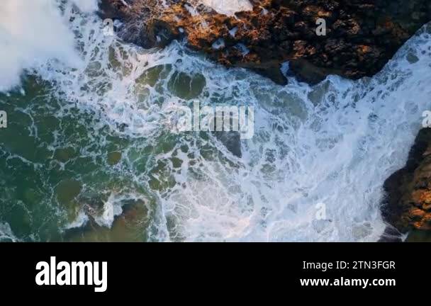Powerful ocean waves crashing on coastal rocks closeup. Top aerial view ...