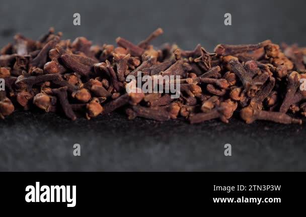 Spices dried cloves on a black background close-up for cooking. The kidneys contain the amount ...