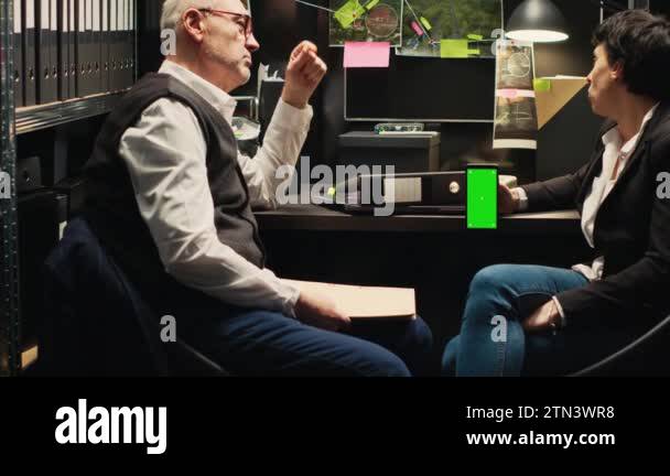 Criminal experts checking greenscreen on smartphone display, working on ...