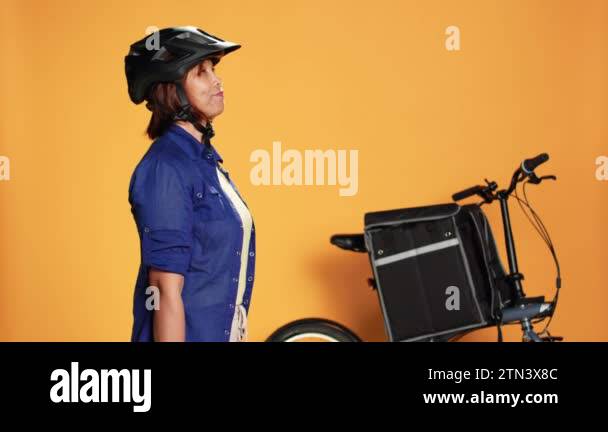 BIPOC food delivery worker reaching order address, waiting for customer ...