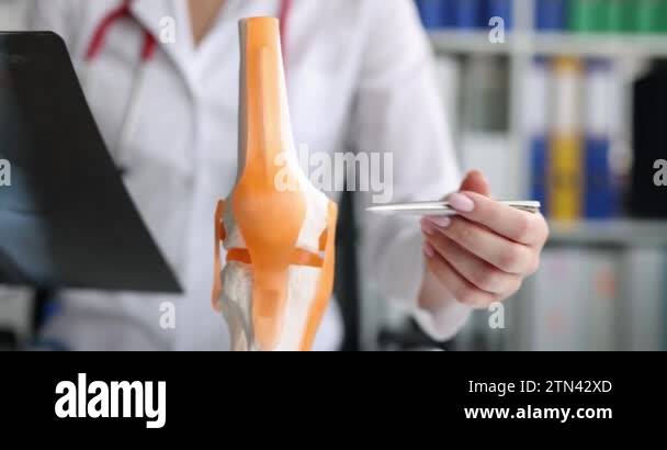 Traumatologist examining x-ray and showing problem on anatomical model ...