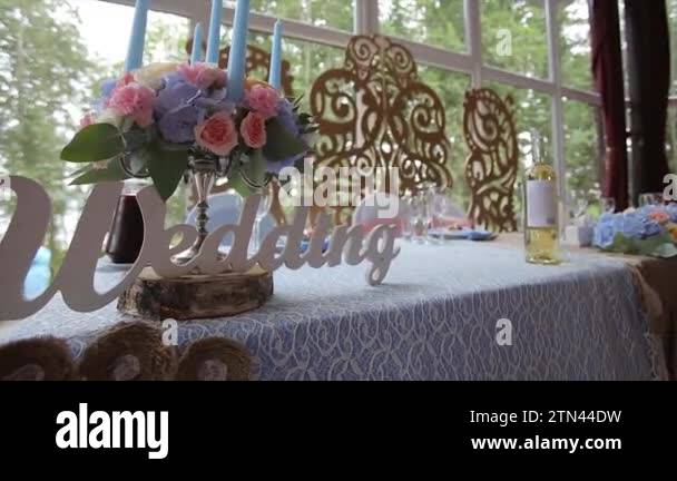 Wedding table at a wedding feast decorated with bridal bouquet. Banquet hall. festive table for ...