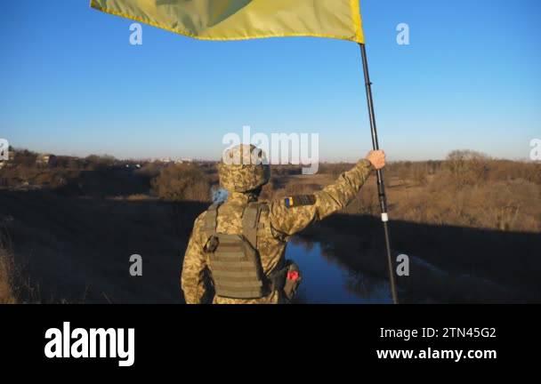 Male ukrainian army soldier lifted blue-yellow banner in honor of the ...