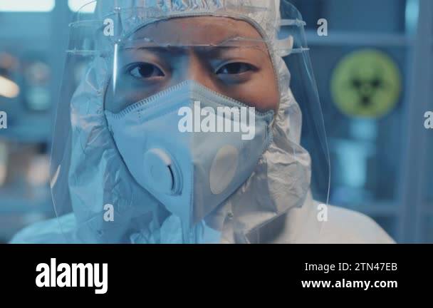 Close-up portrait of female Asian doctor in white hazmat suit ...