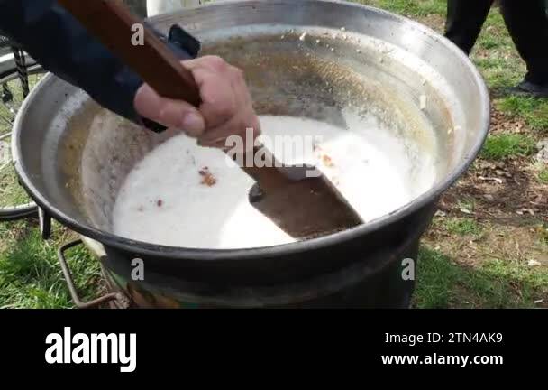 Stirring fat in a large vat on the coals. Pork rind is the culinary ...
