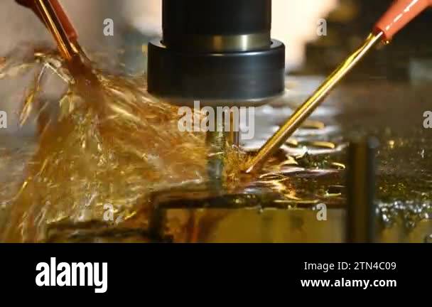 Close up scene the CNC milling machine cutting the mold parts with oil ...