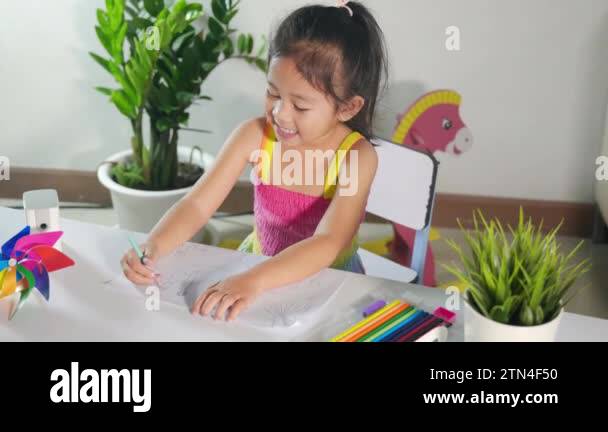 Child little girl drawing cartoon on paper before paint the color ...