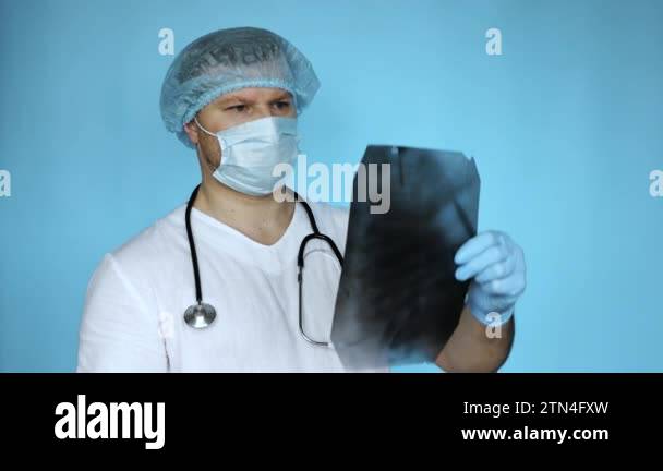 A traumatologist in a medical uniform in a hospital analyzes an x-ray ...