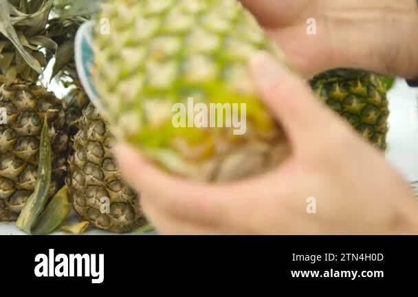 Male hand selecting pineapple at the supermarket. Man taking pineapple ...