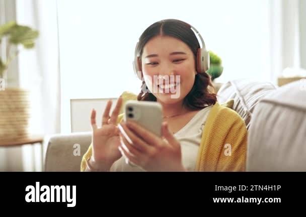 Video call, wave and phone of a woman on a living room sofa with ...