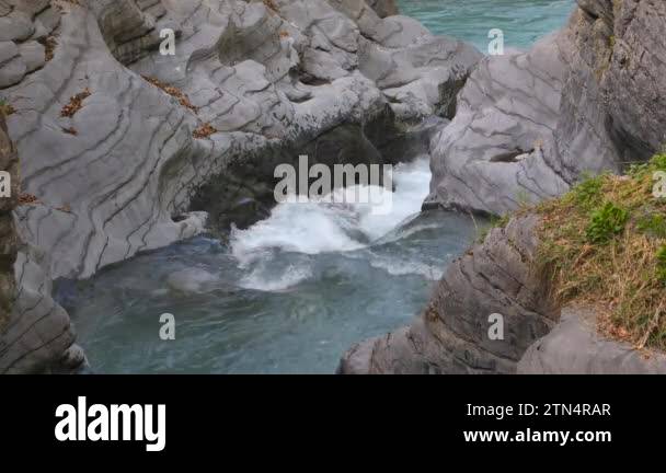 River between rocks of a narrow gorge. Stream of water is squeezed between the sides of the ...