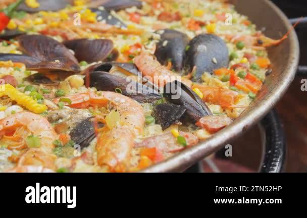 Spanish paella with yellow rice, shrimps and mussels cooking at the ...