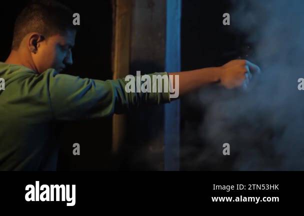 Creative shot of a man with a gun firing someone in the darkness. HD ...