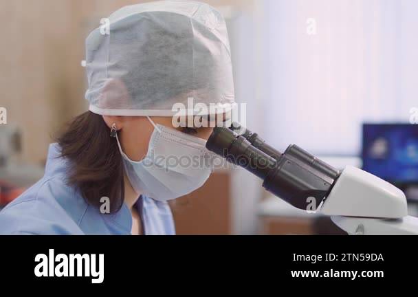 Woman, medical worker with a microscope in the laboratory. She is ...