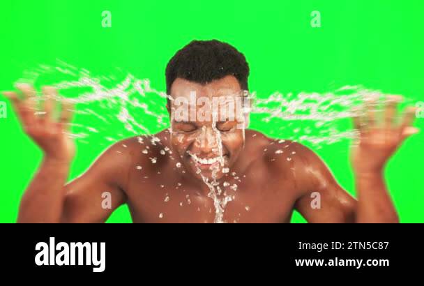 Black man, water splash and green screen for face skincare with a smile and self care ...