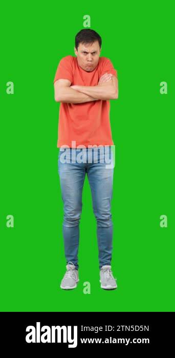 Full body of angry young male with dark hair in orange t shirt and ...