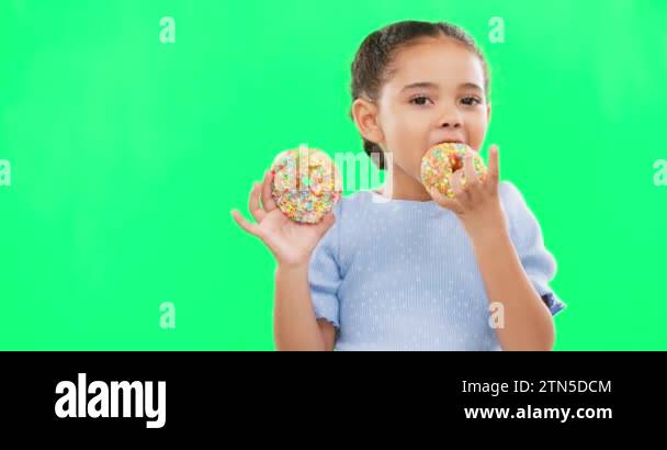 Candy, green screen and child eating donuts in studio with cake for ...
