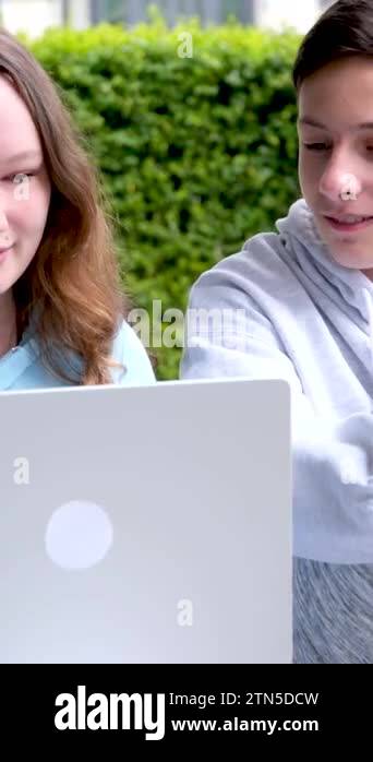 boys teenage girls doing classes task watching movie social networks internet having fun sitting ...