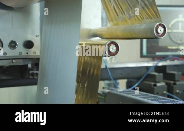 Cellophane package production. Cellophane is moving between the shafts ...