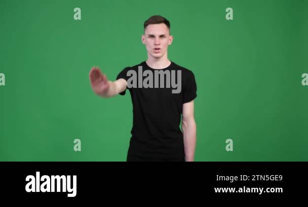 On a vibrant green screen background, a confident Caucasian man is ...